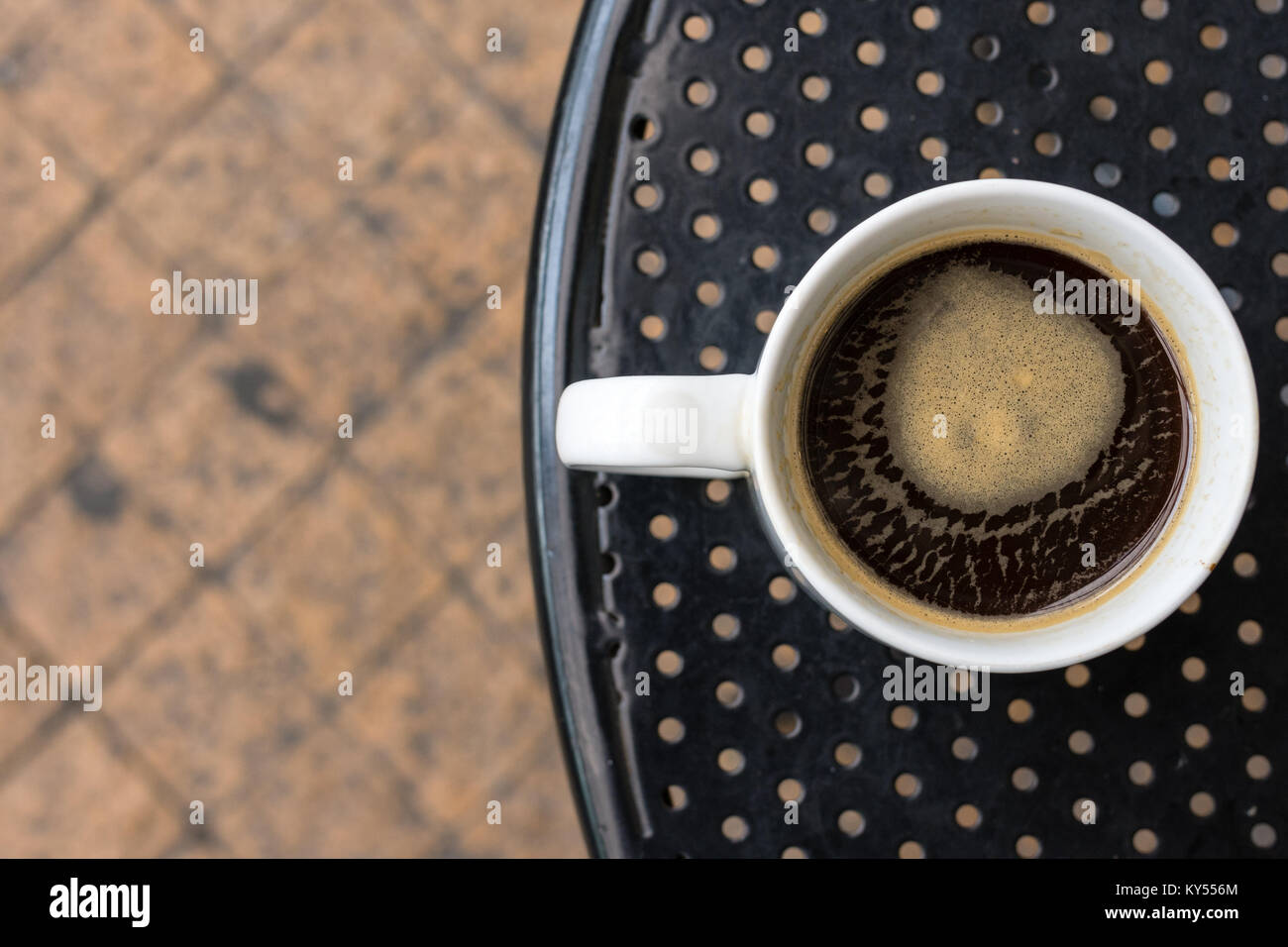 Americano coffee in standard white mug on black metal table from above ...
