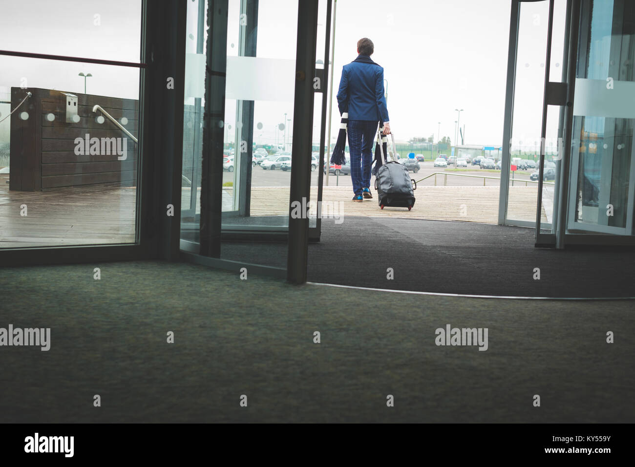 Businessman walking out of the hotel with baggage Stock Photo - Alamy