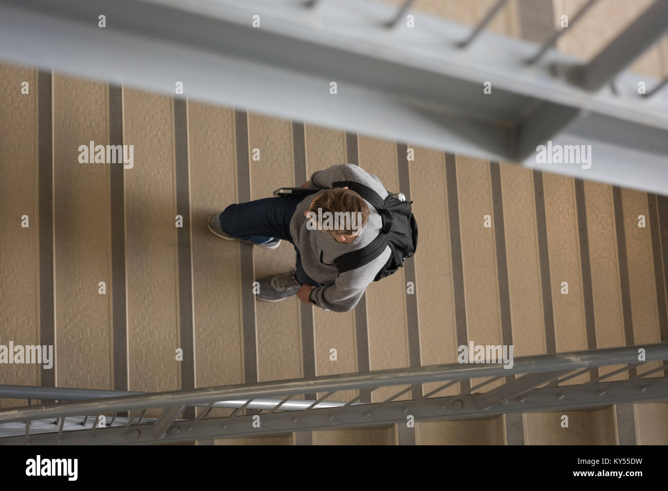 College student walking with laptop on staircase Stock Photo - Alamy