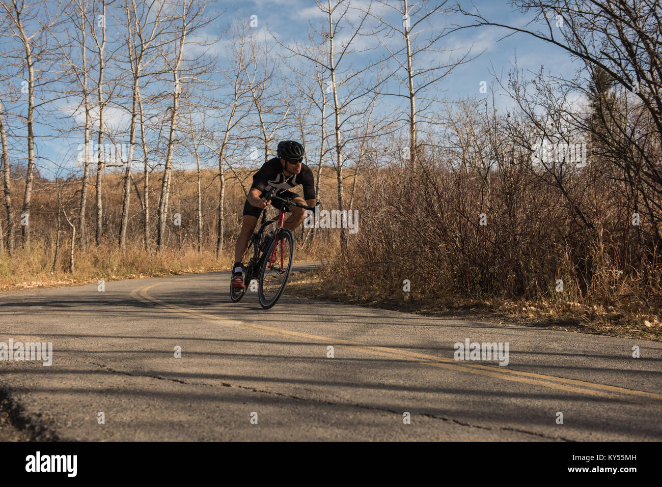 Biker riding mountain bike on road Stock Photo - Alamy