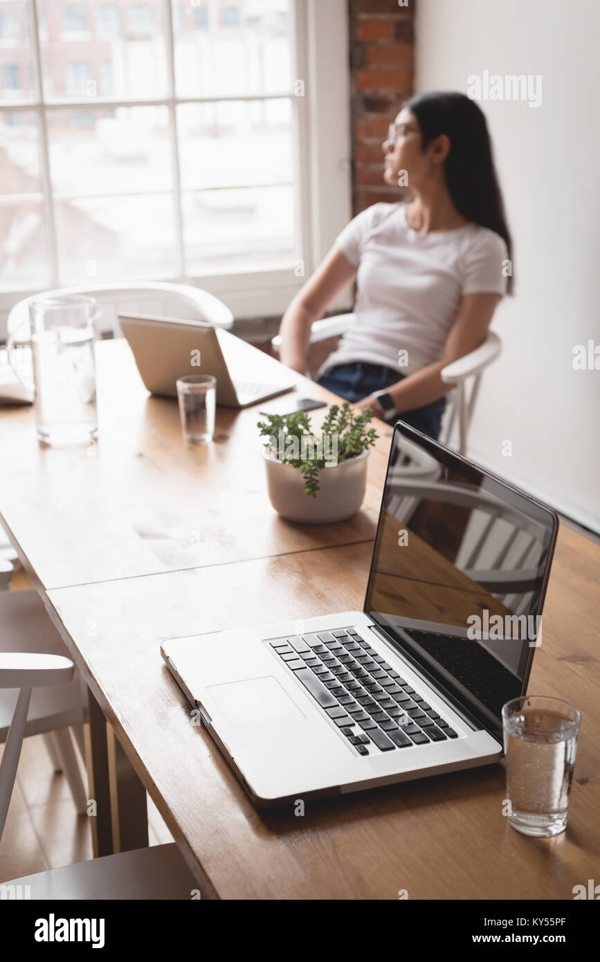 Thoughtful female executive sitting on chair Stock Photo - Alamy