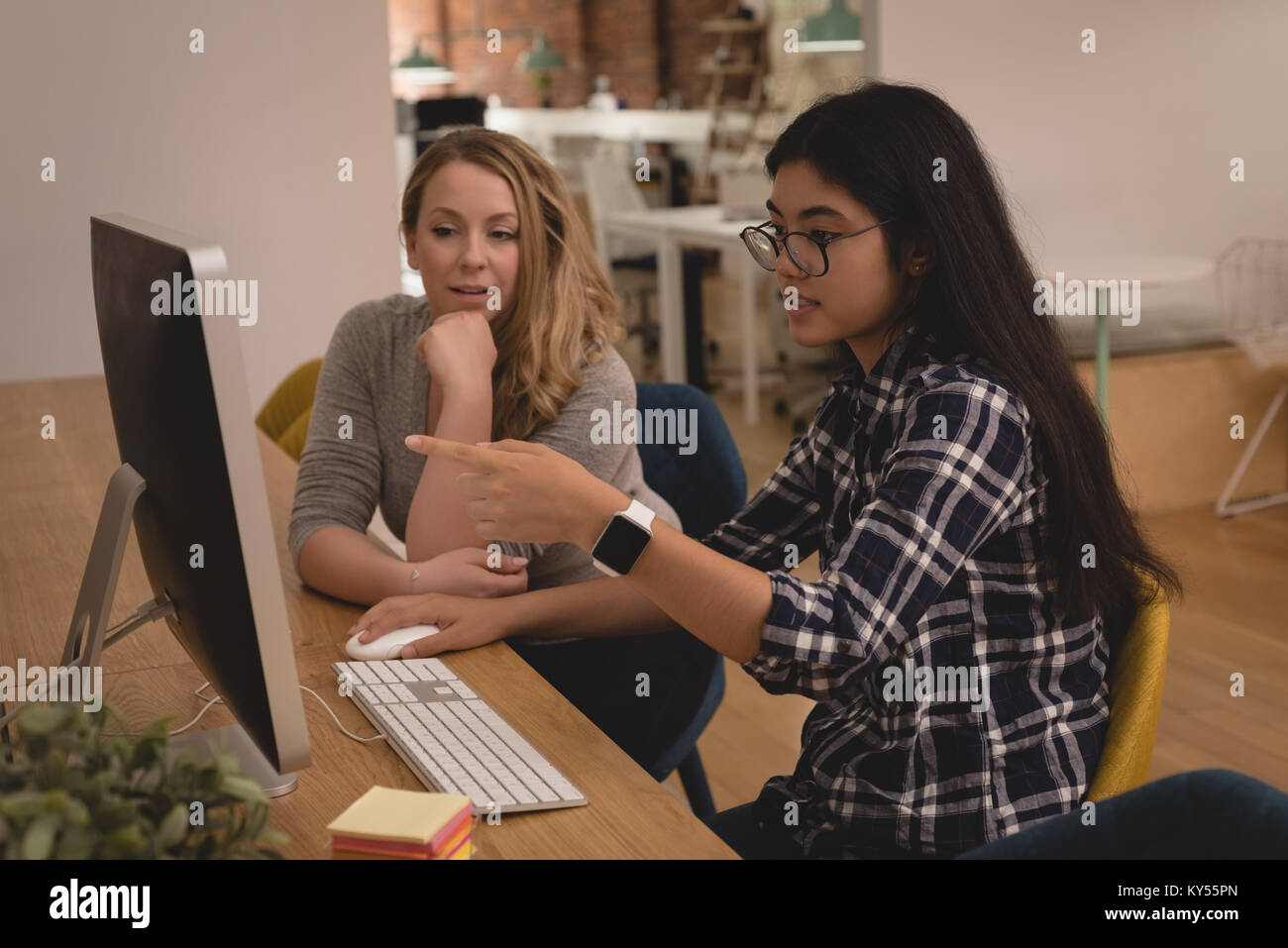 Female executives discussing over computer Stock Photo - Alamy