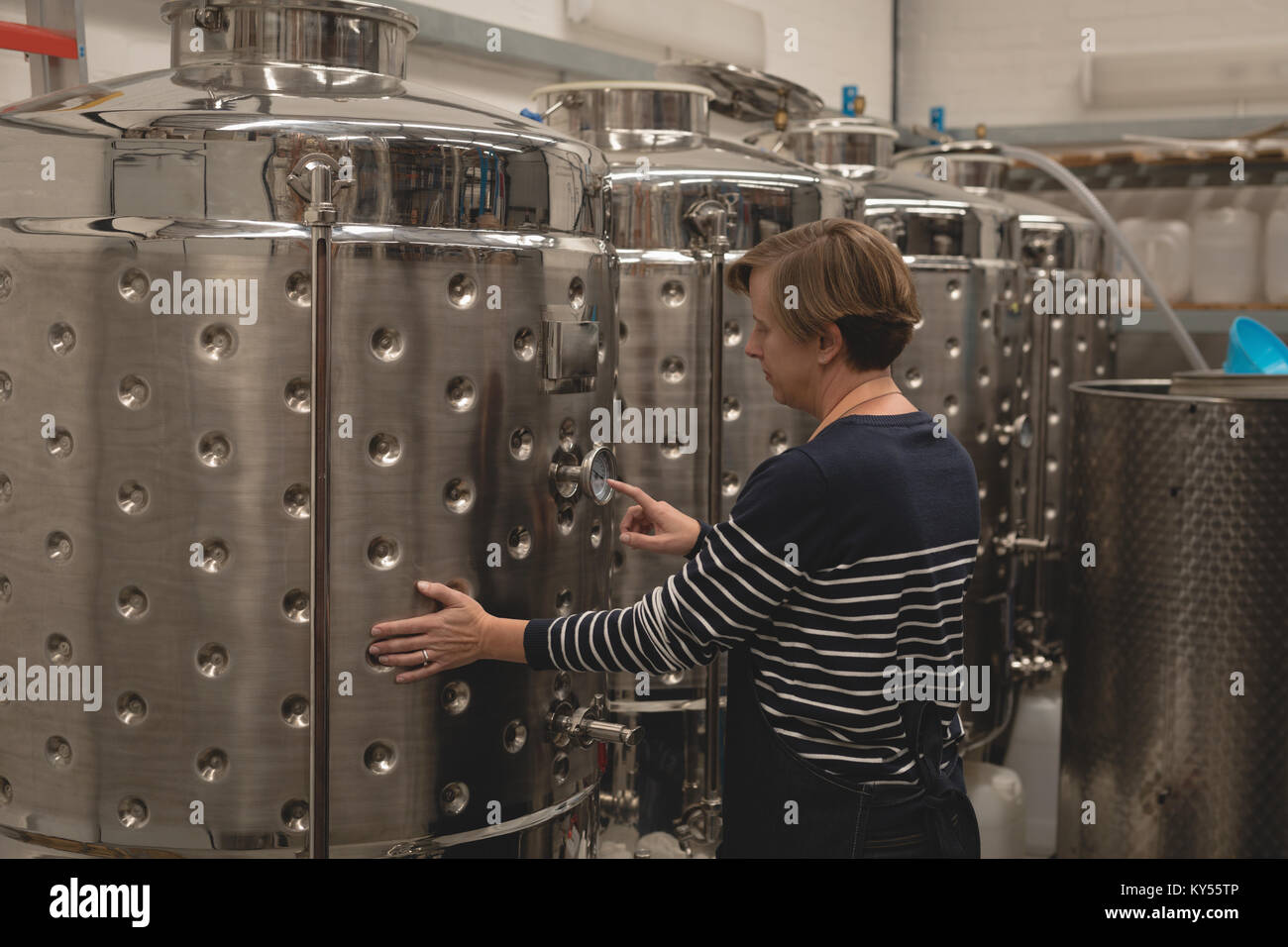Female worker monitoring a pressure gauge of storage tank Stock Photo ...