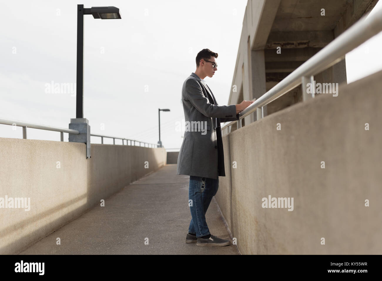 Man using mobile phone on bridge Stock Photo - Alamy