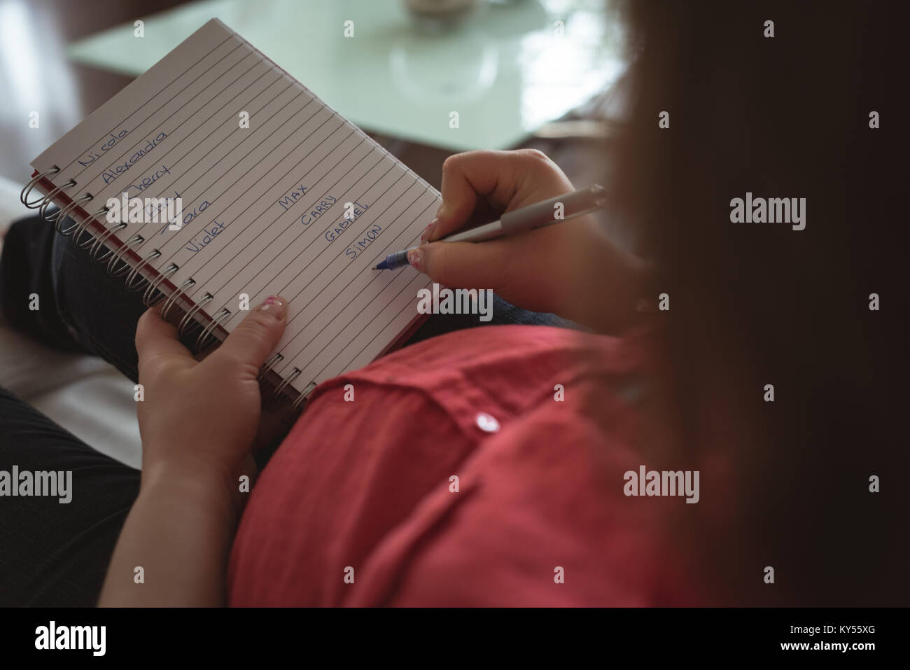 Pregnant woman writing in notebook Stock Photo - Alamy