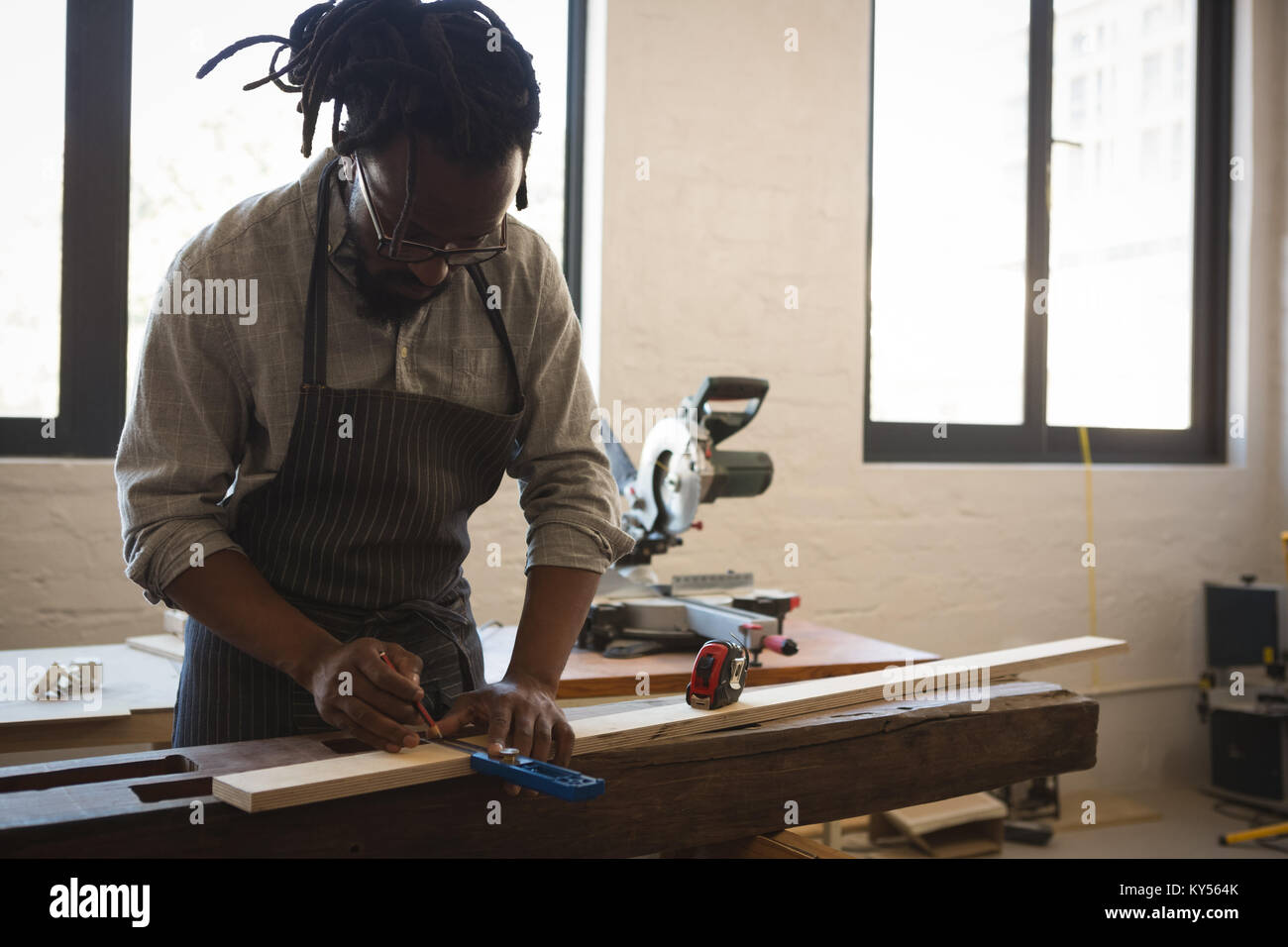 Carpenter measuring wooden plank with scale Stock Photo - Alamy