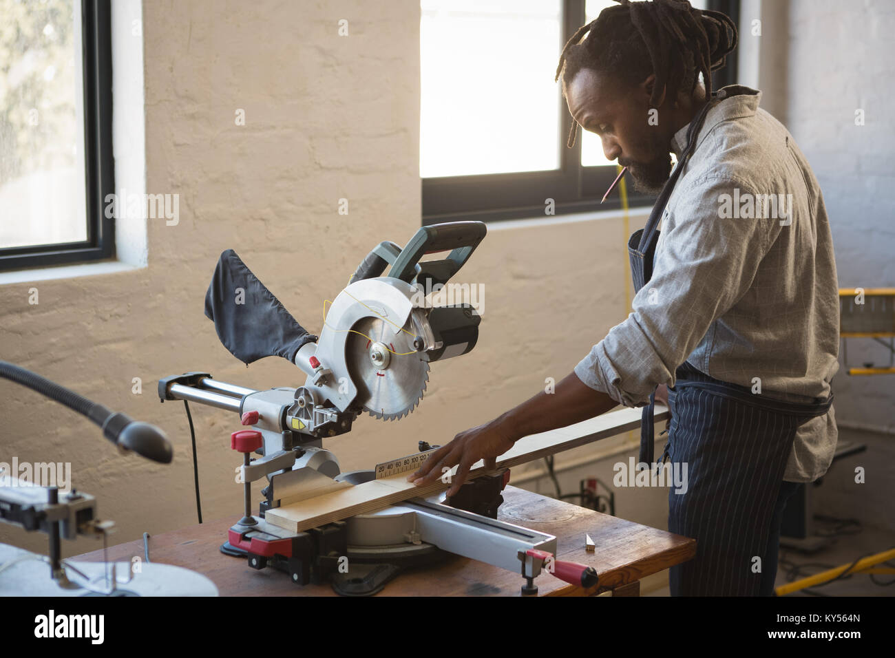 Carpenter measuring wooden plank with scale Stock Photo - Alamy