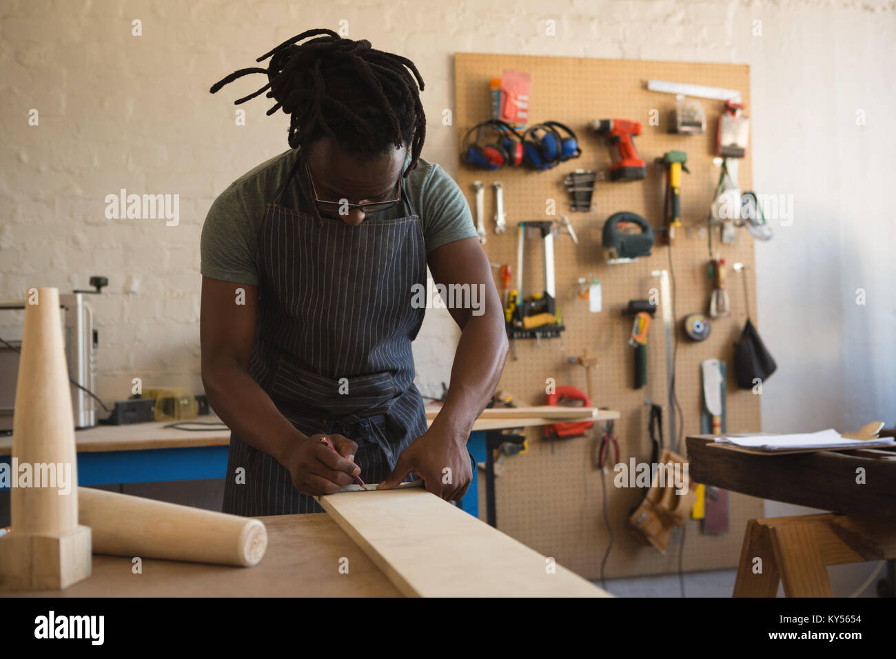 Carpenter measuring wooden plank Stock Photo - Alamy