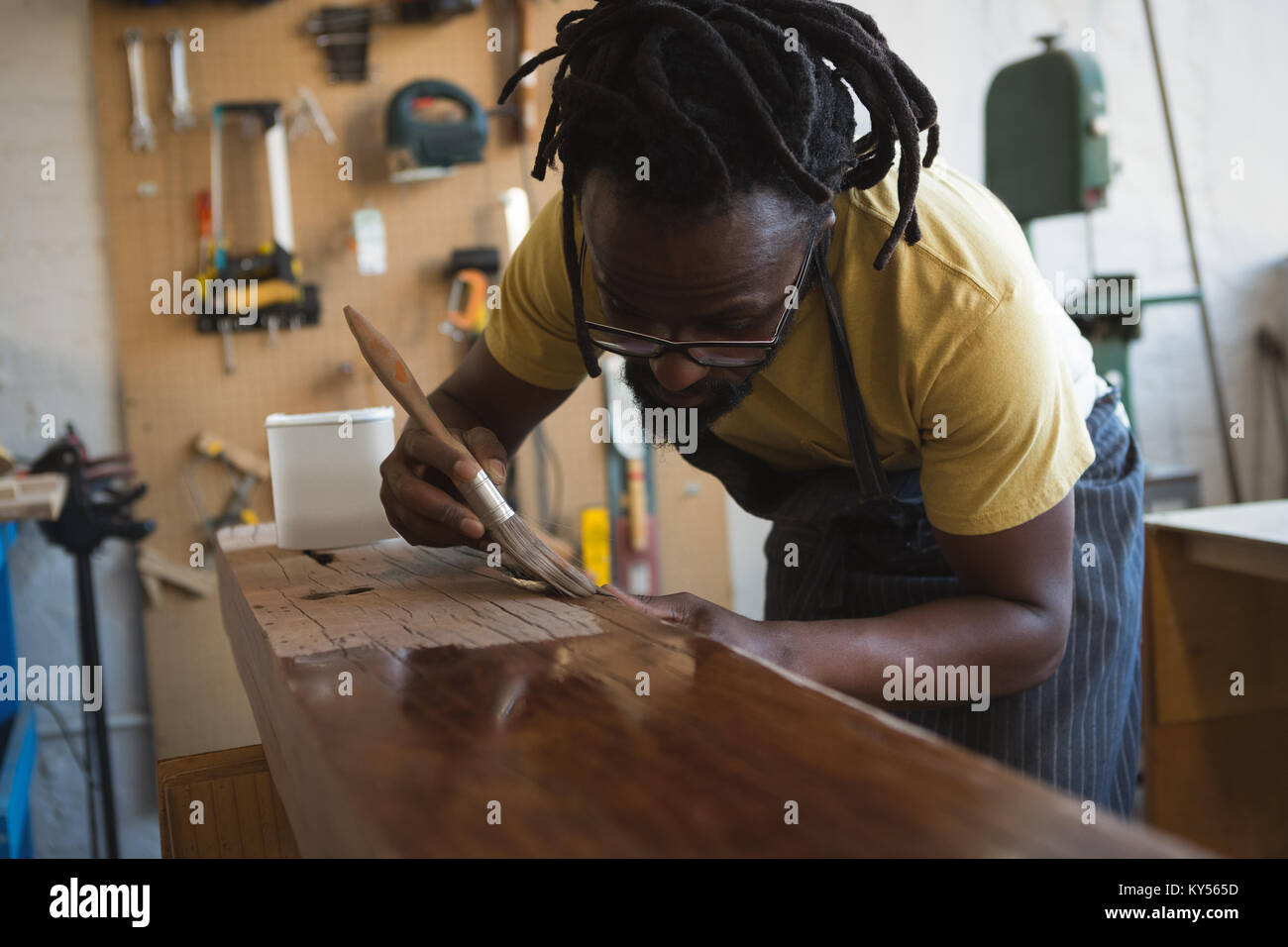 Carpenter painting wooden plank Stock Photo - Alamy