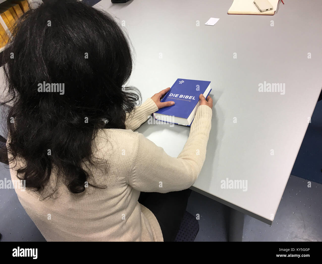 A 42 year old, newly baptized as Alexandra, sits at a table with a ...