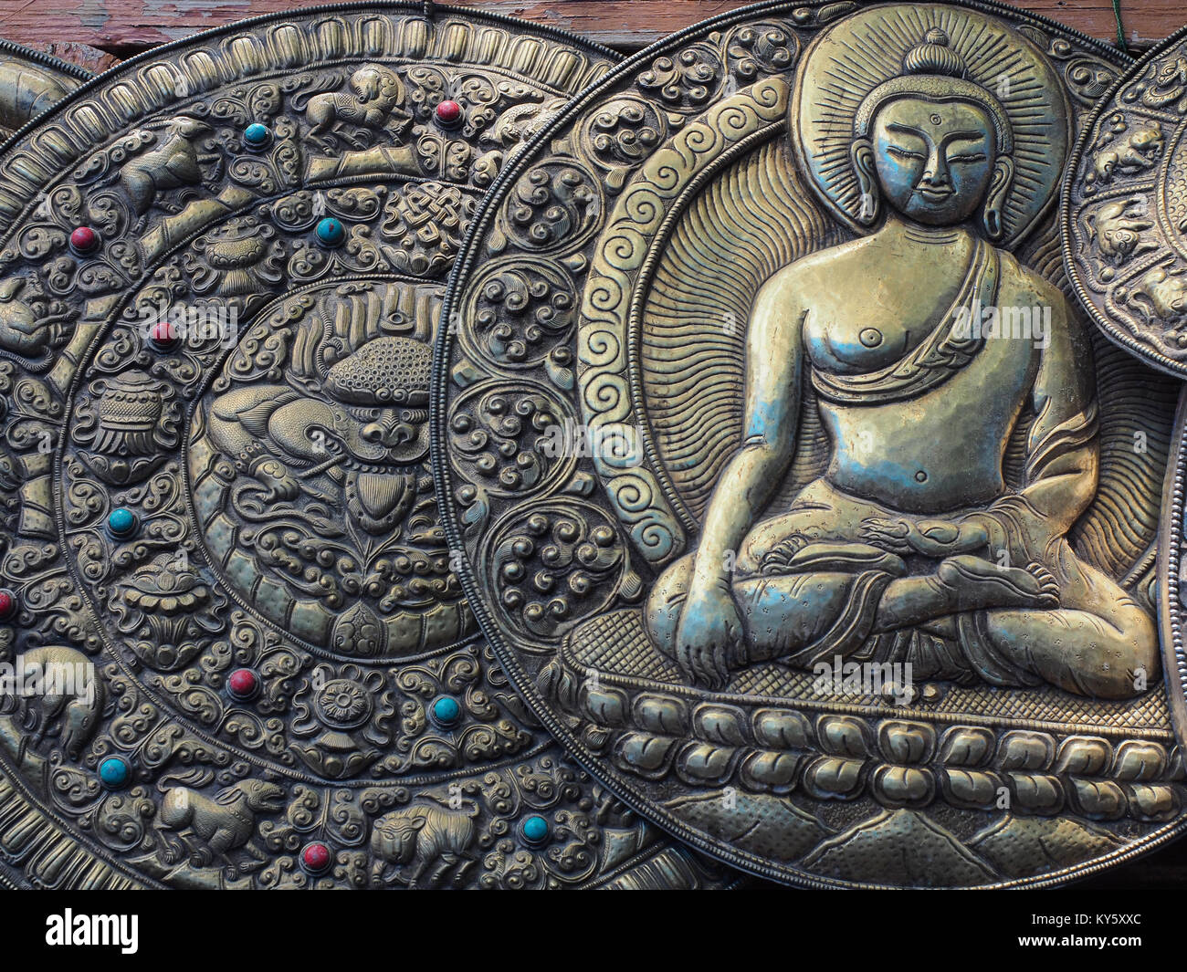 Image of a seated Buddha on a bronze metal plate, a wall decoration ...