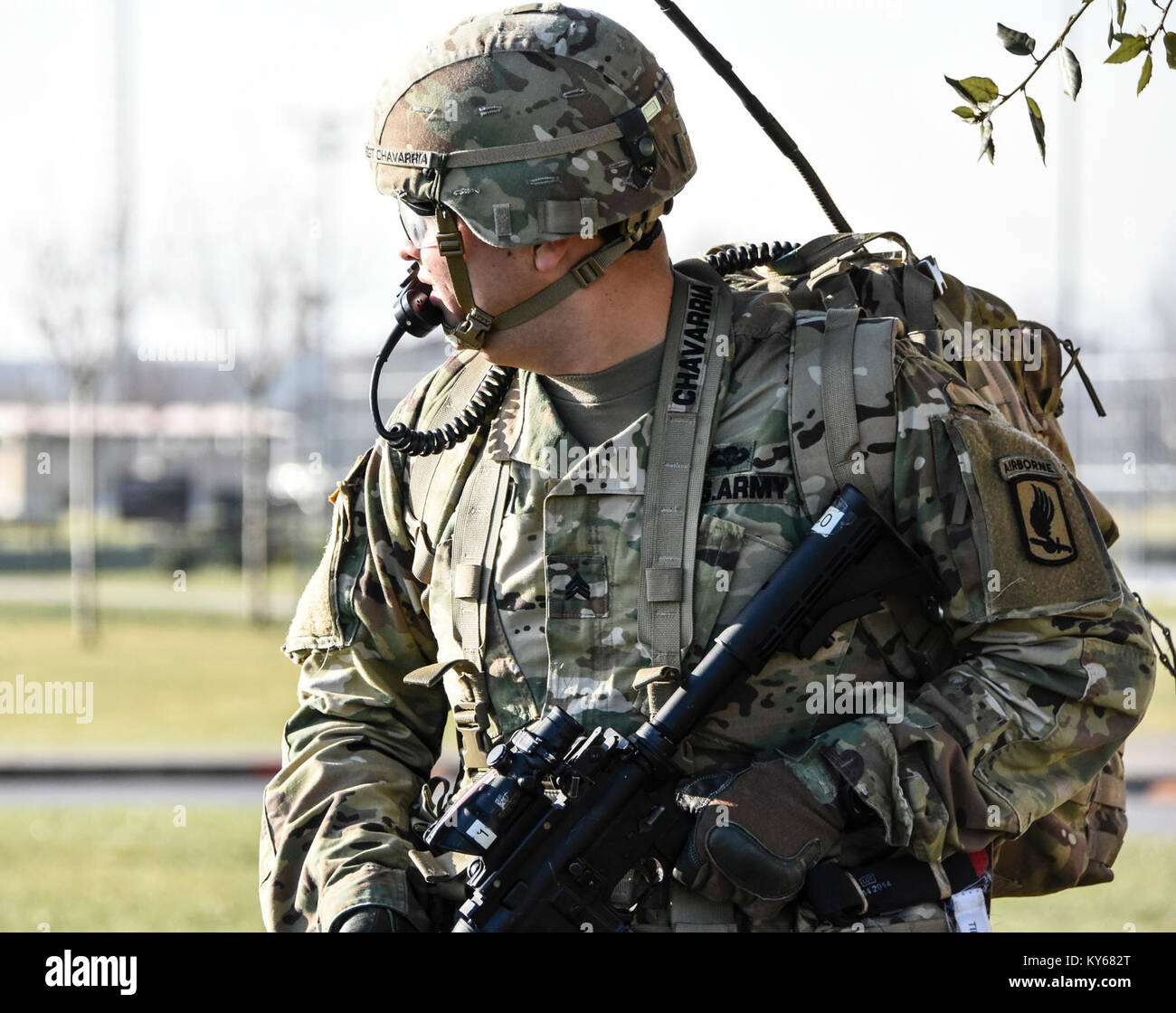 A sergeant communicates with his platoon as they move tactically ...