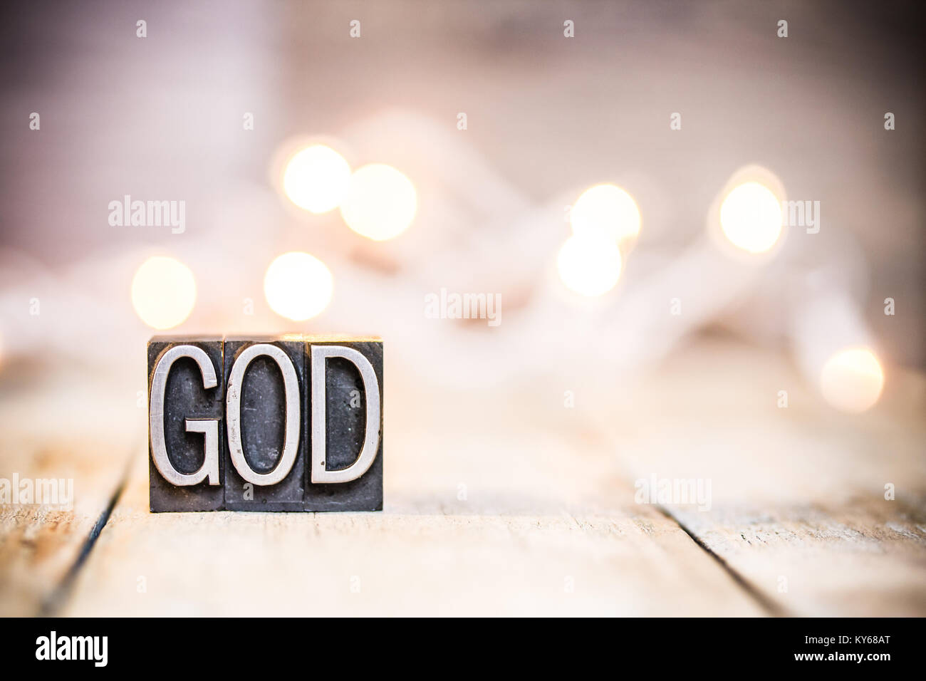 GOD written in vintage metal letterpress type on a bokeh light and ...