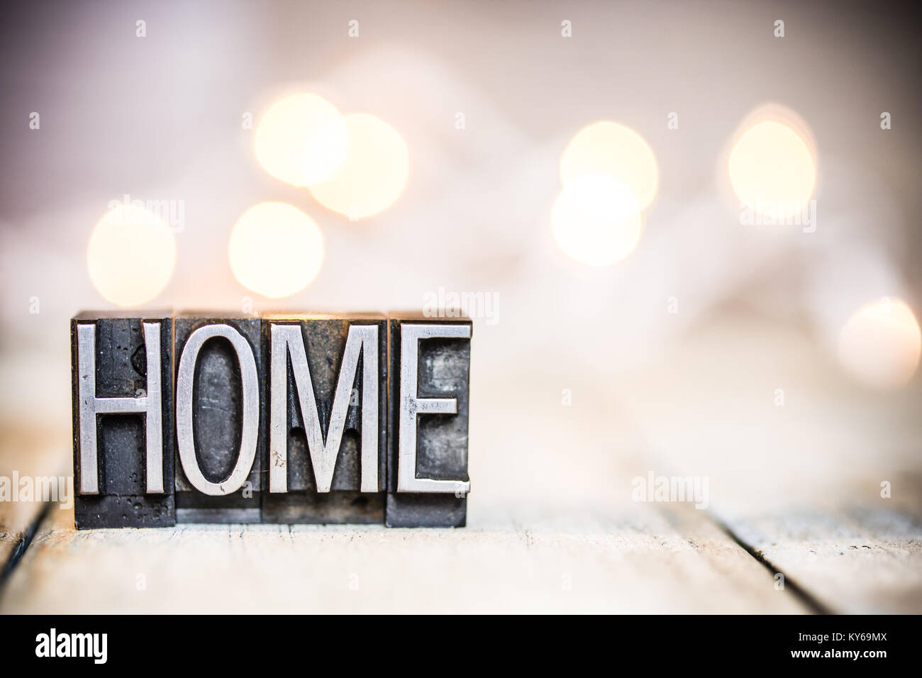 The word HOME written in vintage metal letterpress type on a bokeh ...