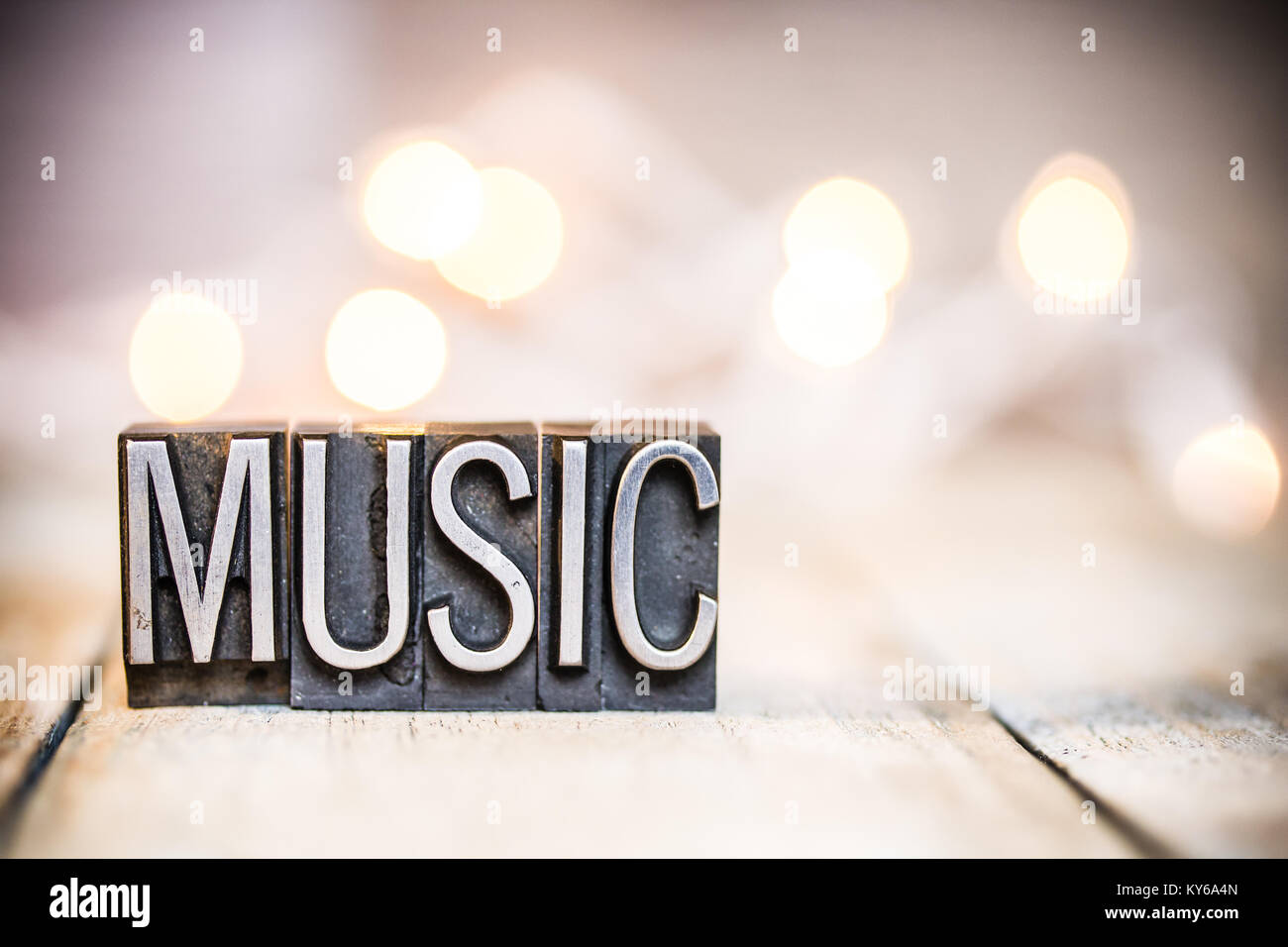 The word MUSIC written in vintage metal letterpress type on a bokeh ...