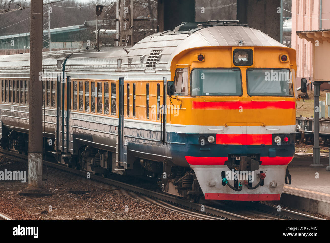 Old yellow passenger diesel train moving at the terminal Stock Photo ...