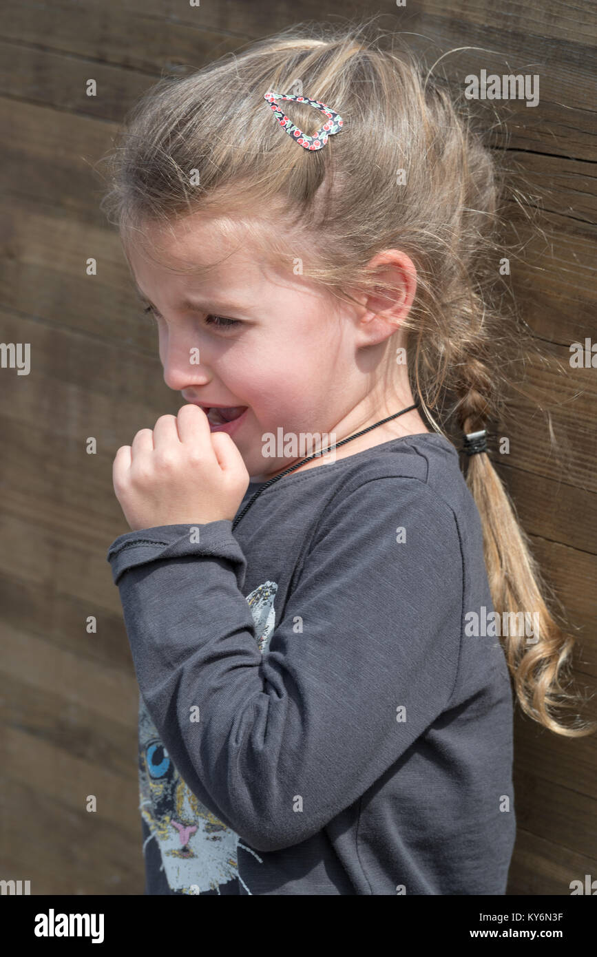 Little girl cry beside wooden wall Stock Photo - Alamy
