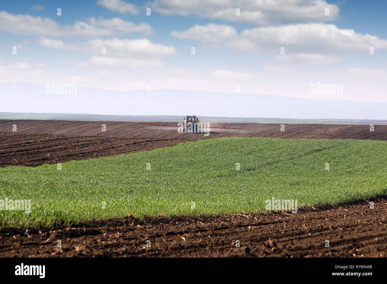 tractor spraying field at spring agriculture Stock Photo - Alamy