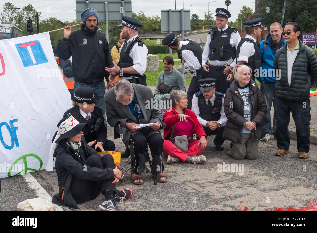 Police come and talk to the people blocking the road, telling them they ...