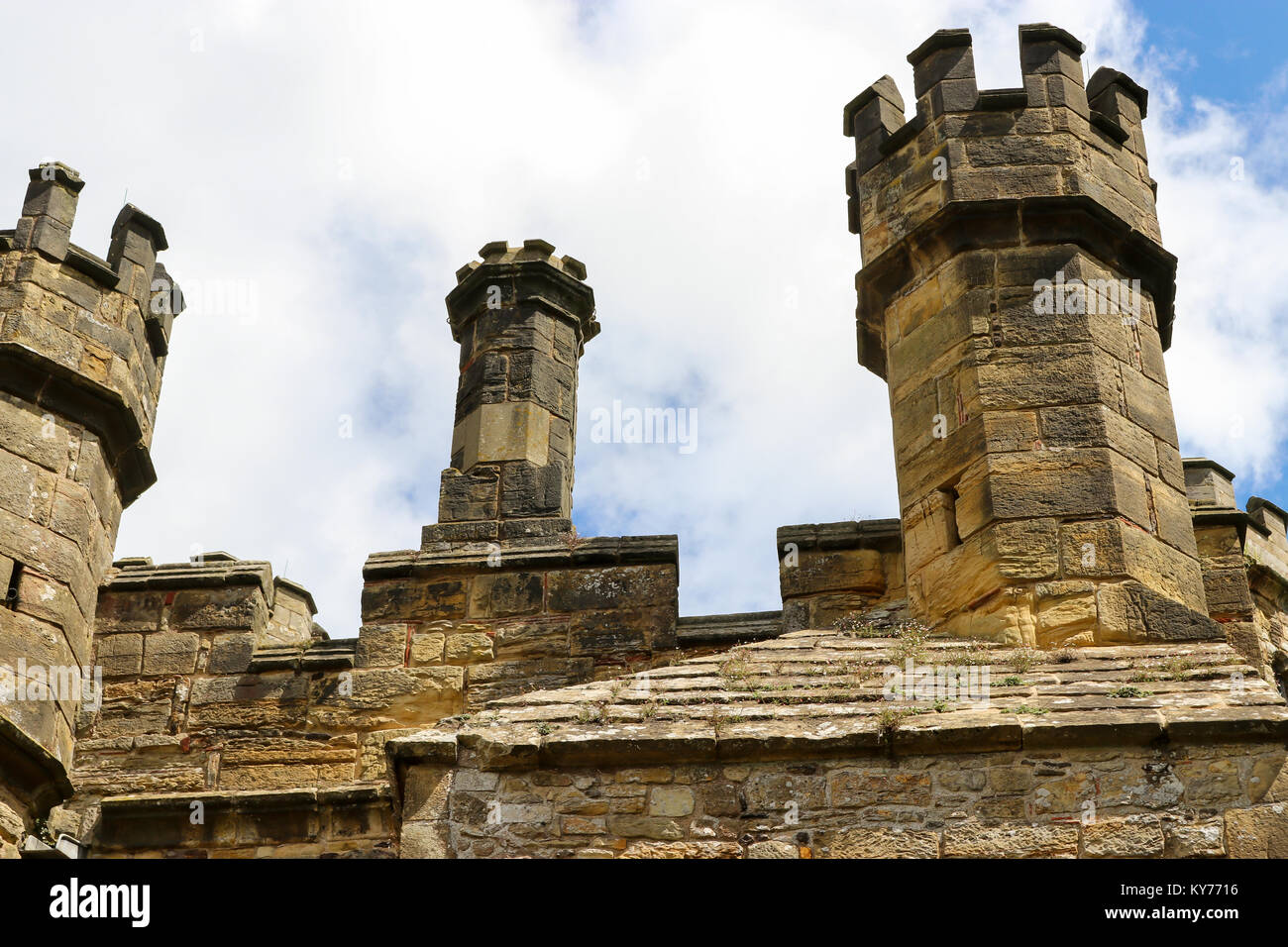 Old stone turrets of the Battle Abbey Gatehouse against the blue summer ...