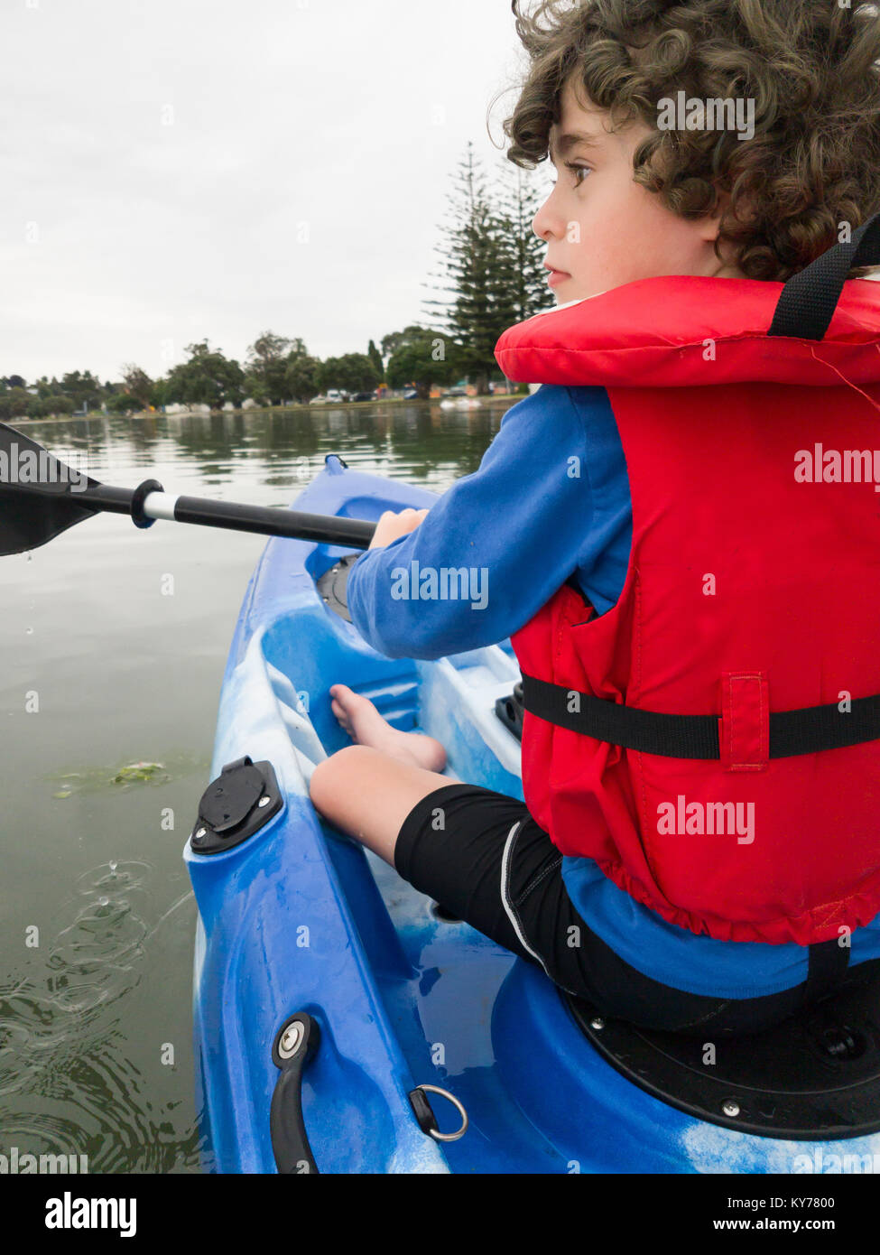 In a kayak with small boy paddling and looking around Stock Photo - Alamy