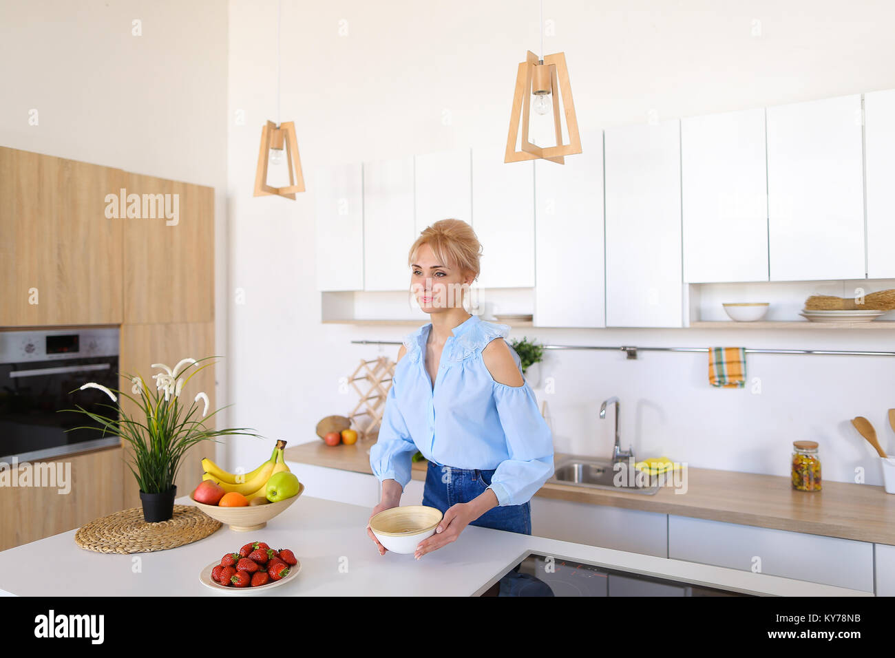 Slender, sweet woman cooks delicious breakfast of oatmeal and ripe red ...
