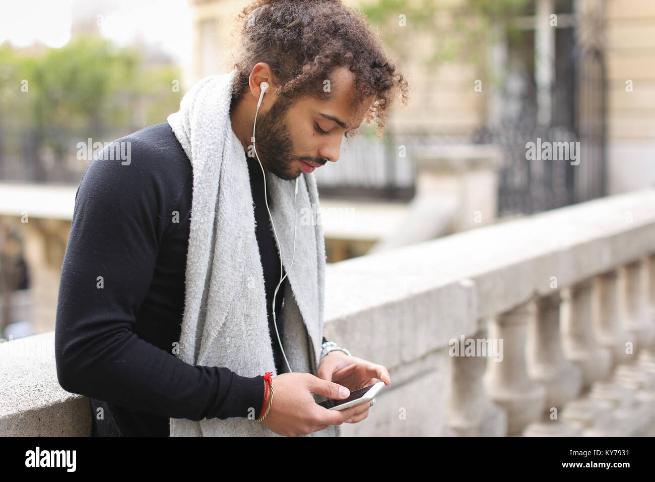 Handsome mix blood boy typing message and listening to music with white ...