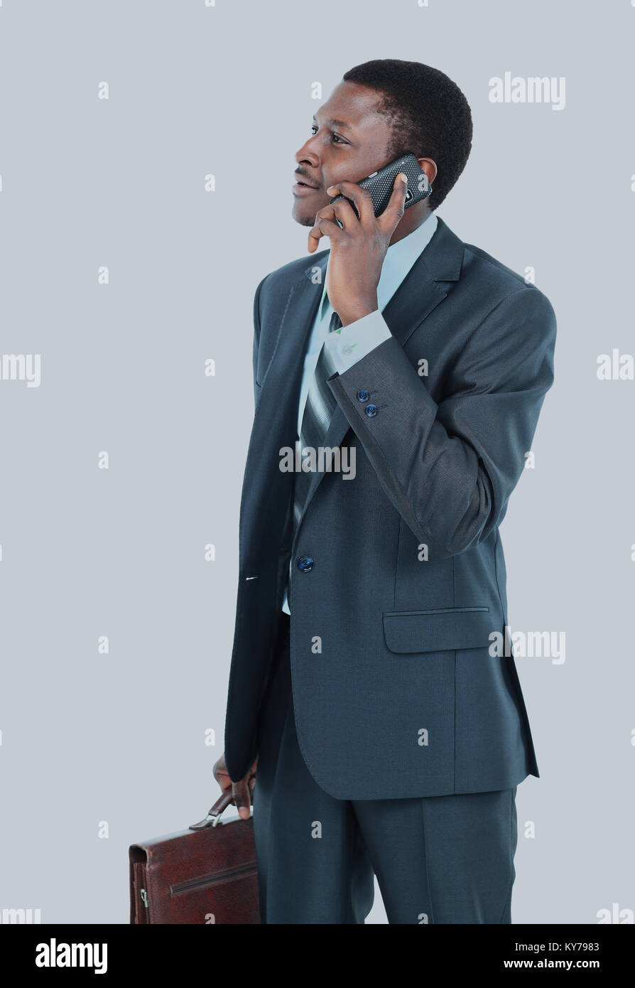 Young entrepreneur holding his coat over shoulder while talking on cell ...