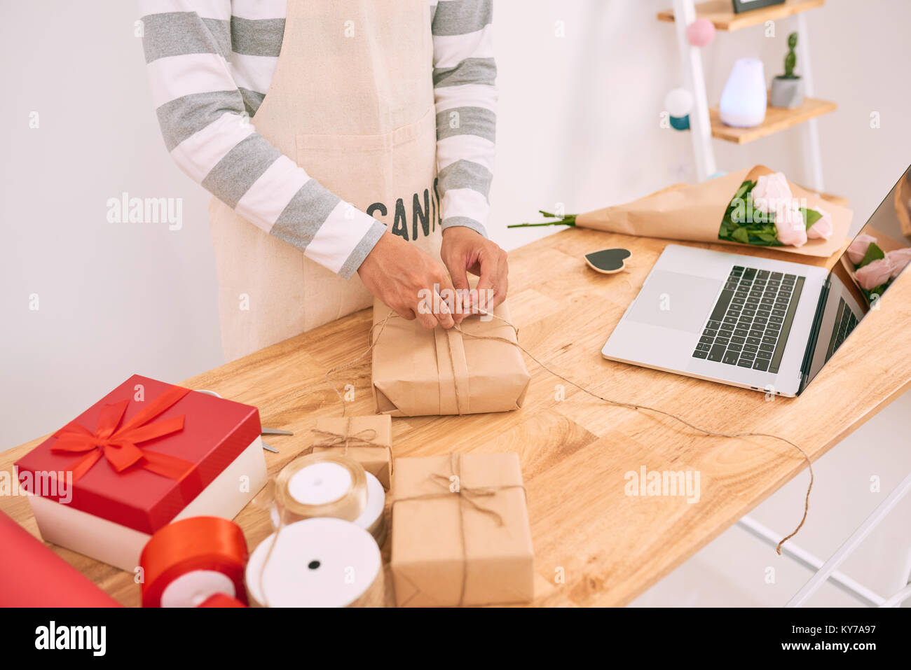 Asian man wrapping purchase while working in shop of gifts Stock Photo ...