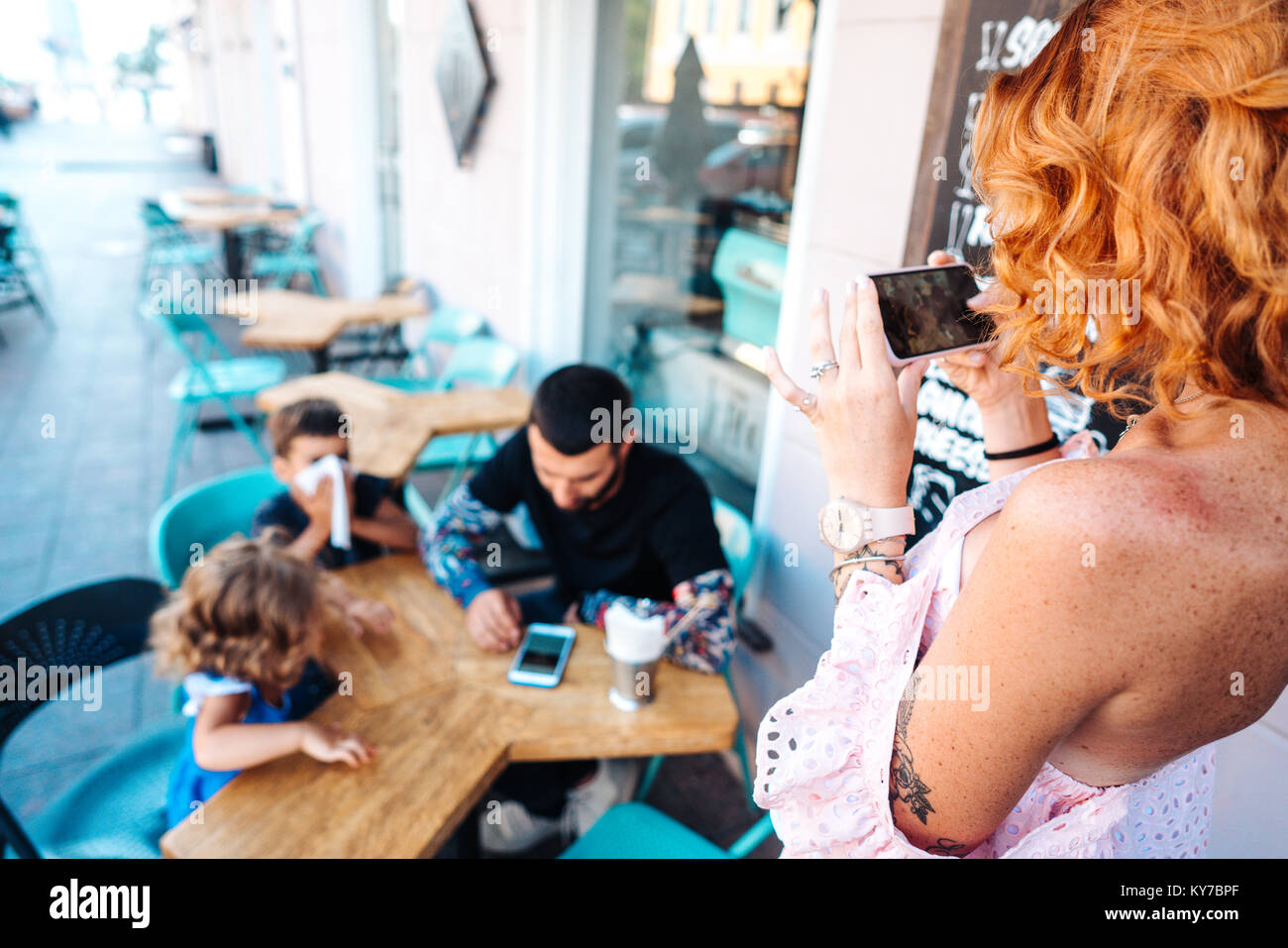 family in a cafe, mom takes a photo Stock Photo - Alamy