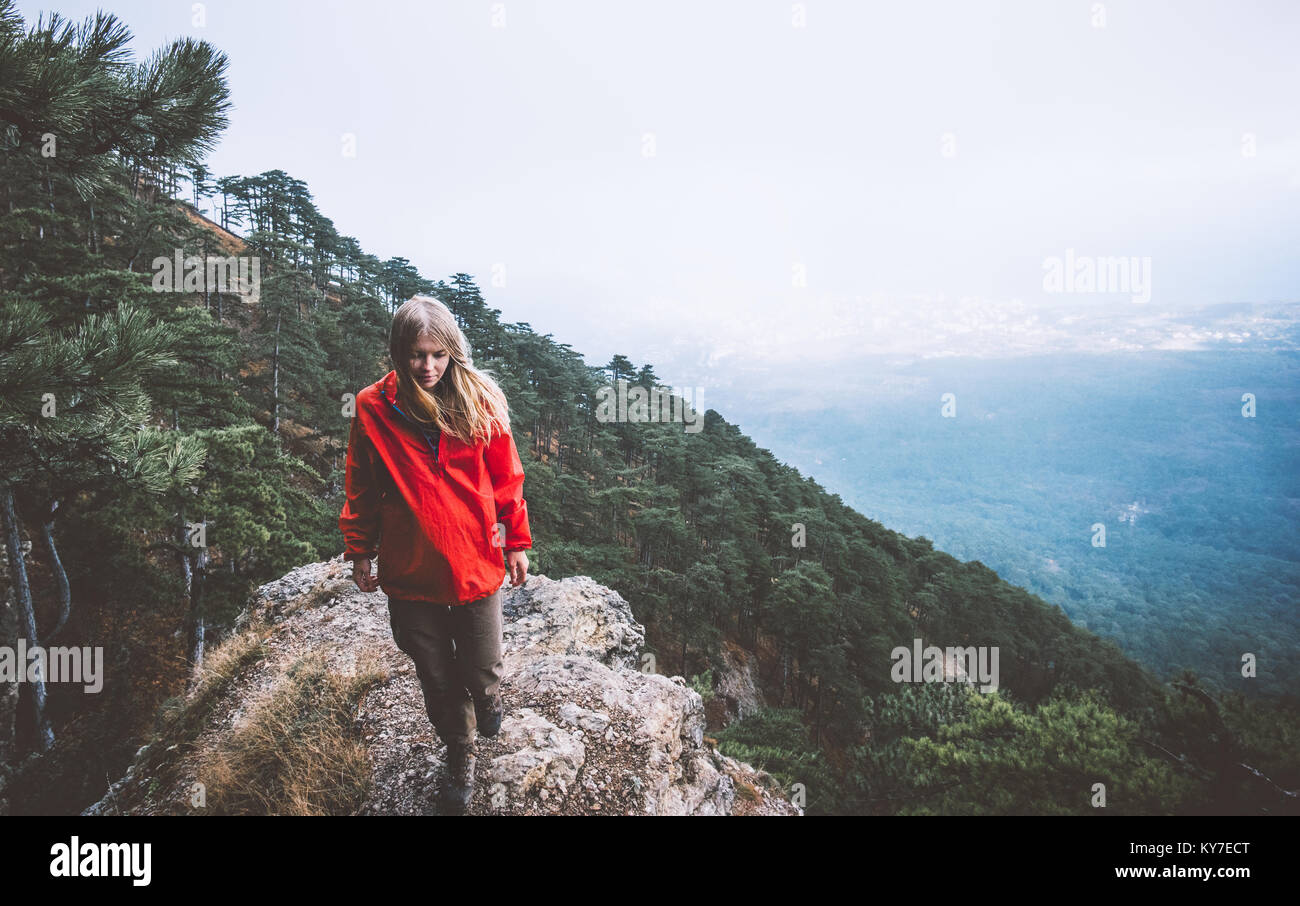 Woman Traveler walking on mountains cliff alone aerial view forest on ...