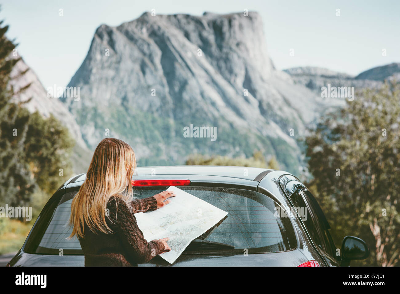 Woman traveling by car on road trip with map planning route Lifestyle ...