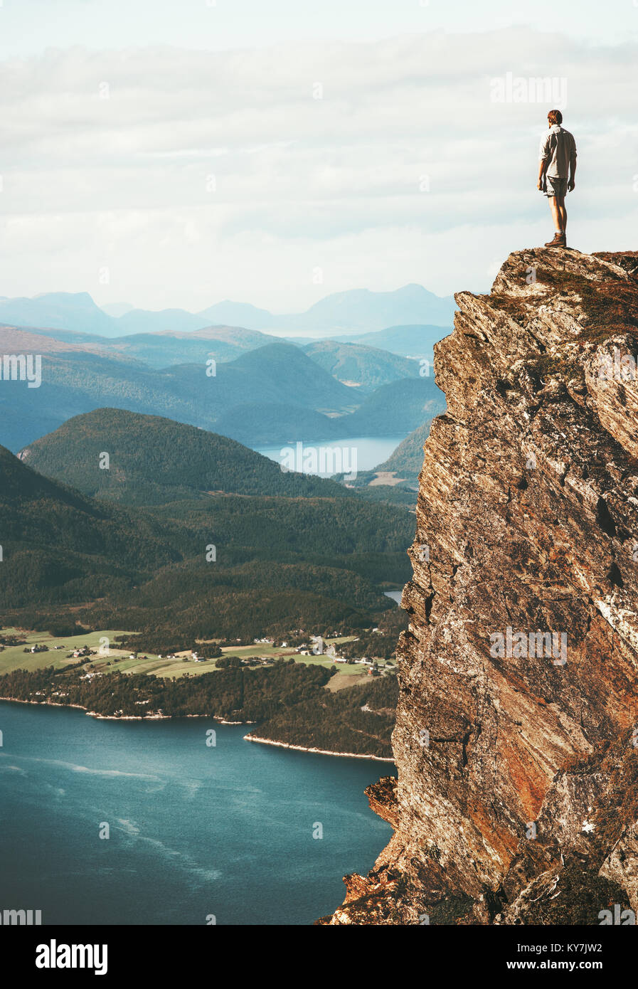 Man standing on cliff mountains over fjord Norway landscape Travel ...