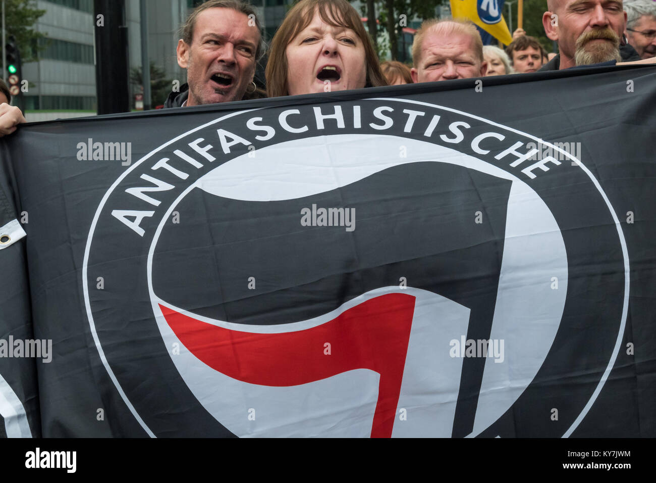 Anti-fascist protesters with an 'Antifaschistische' banner shout at the ...