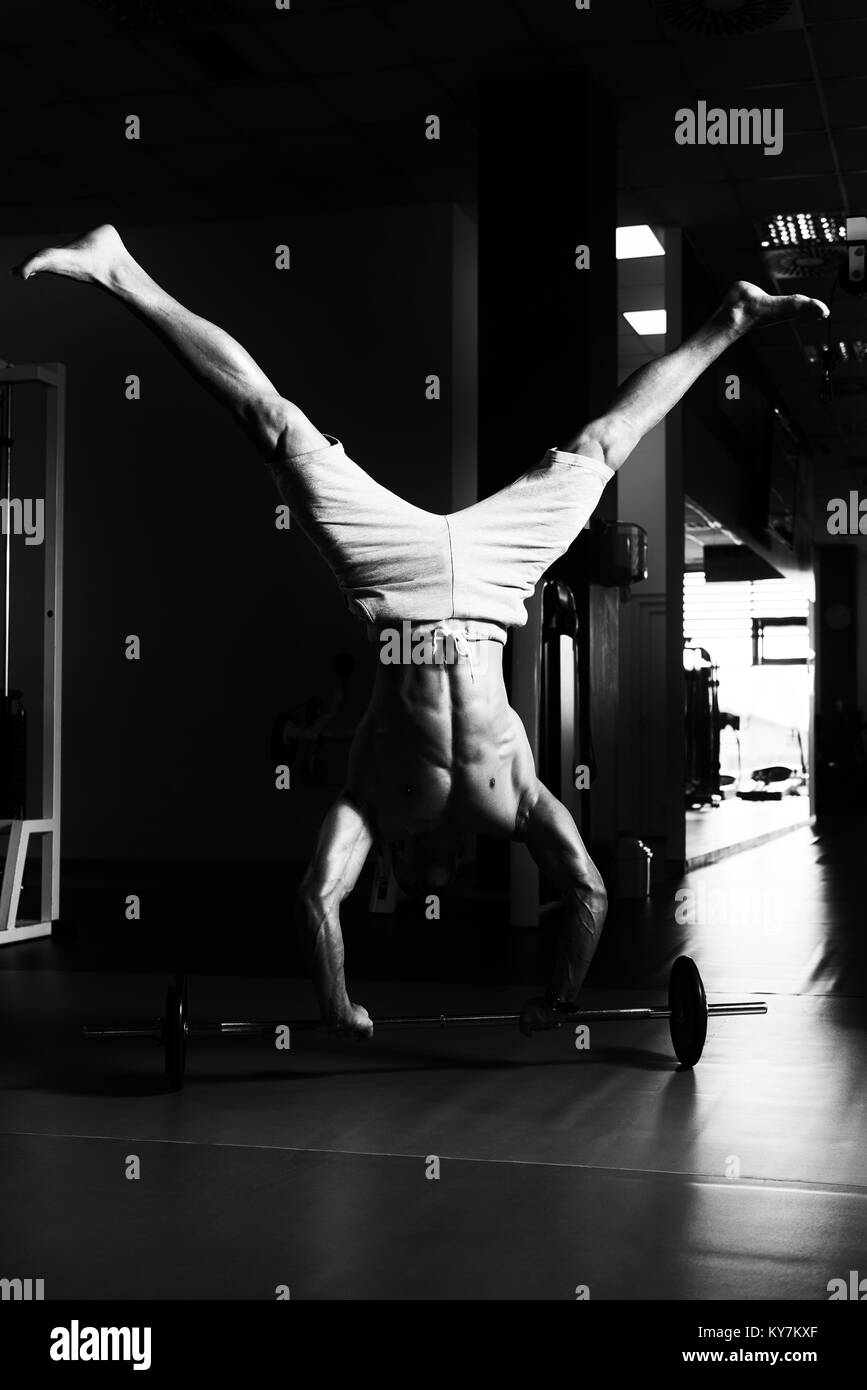 Bodybuilder Doing Handstand Push Ups On Barbell As Part Of Bodybuilding ...