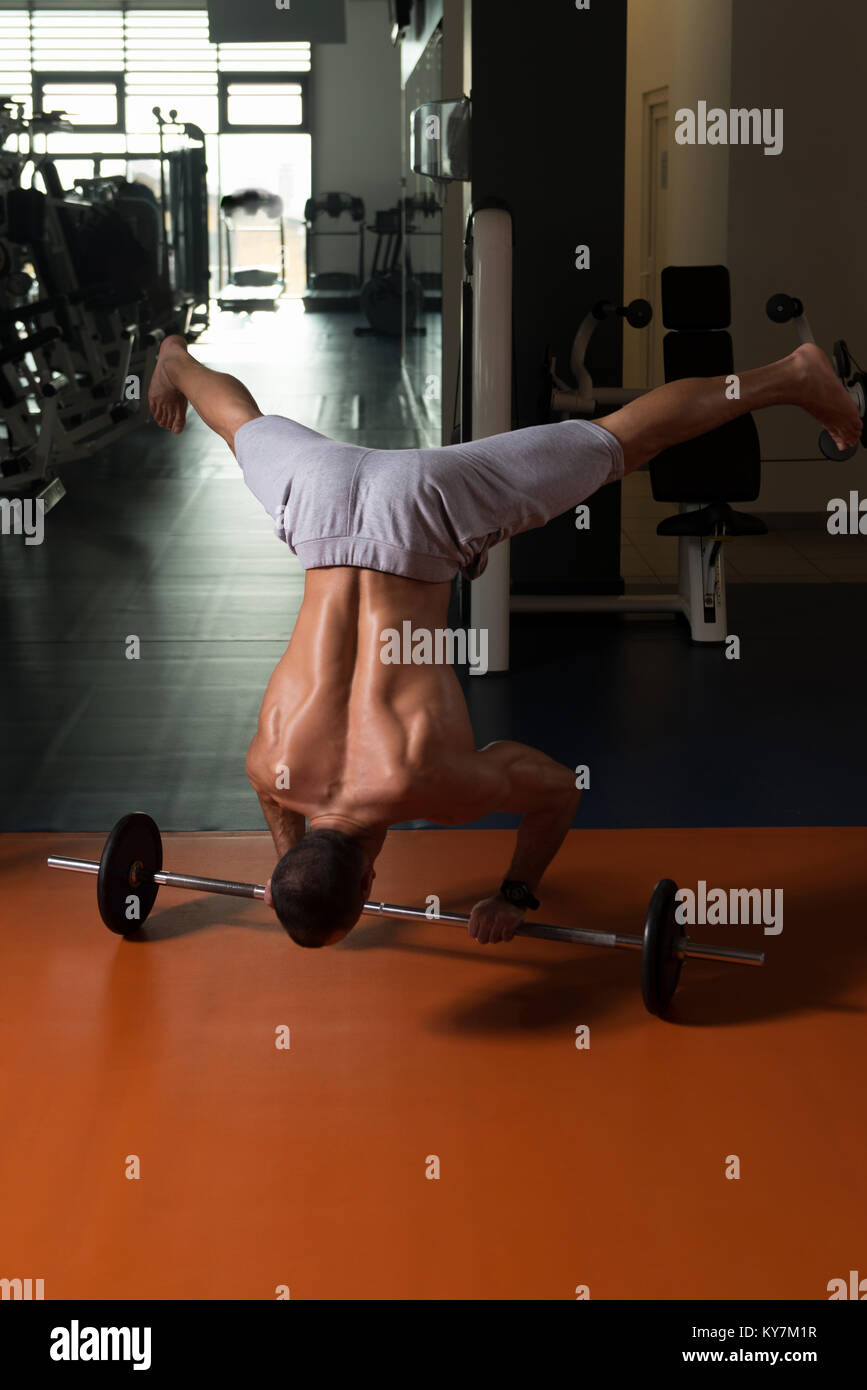 Bodybuilder Doing Handstand Push Ups On Barbell As Part Of Bodybuilding ...