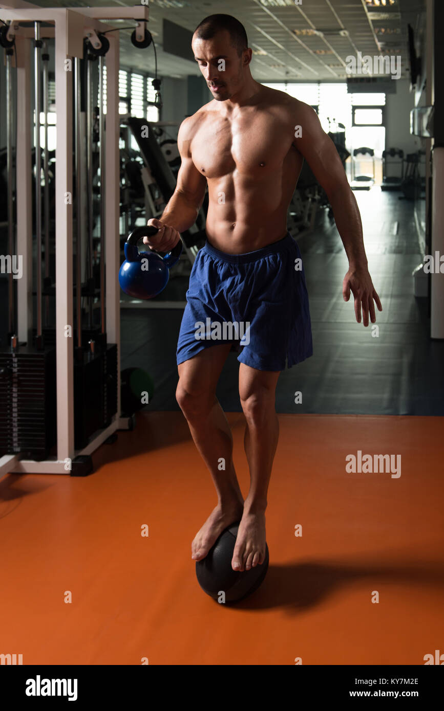 Athlete Doing Kettle Bell Exercise On Medicine Ball As Part Of ...