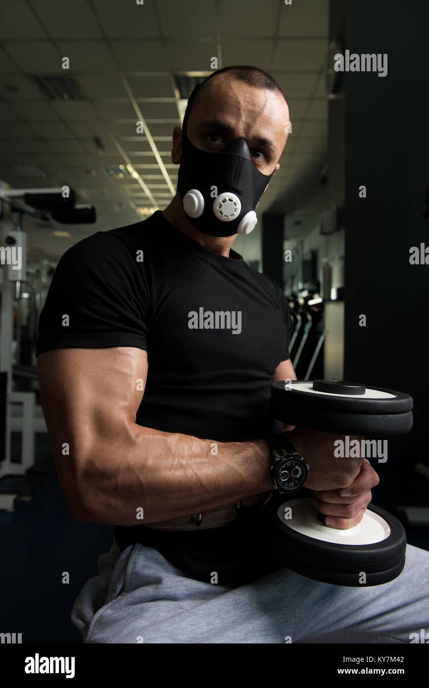 Athlete Working Out Biceps In Elevation Mask - Dumbbell Concentration ...