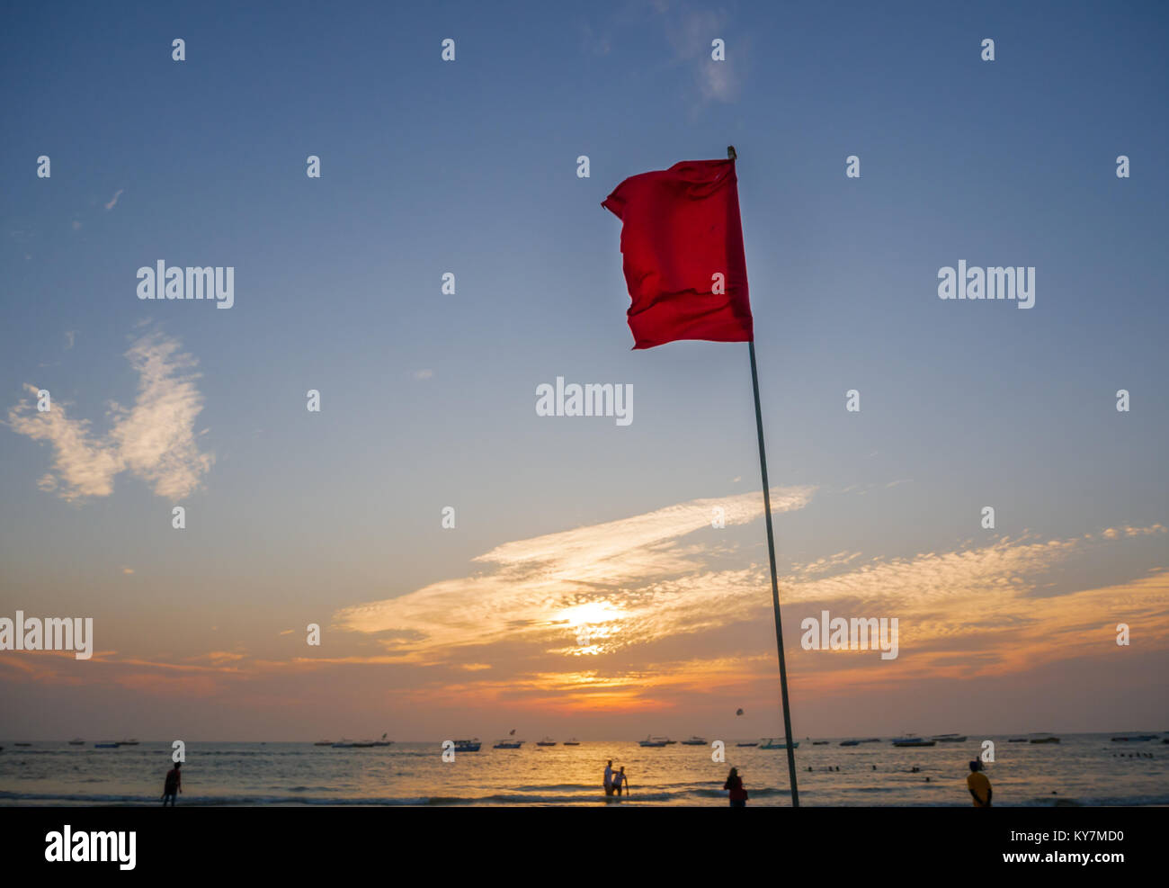 Red flag by the sea with sunset background. Evening seaside scene with ...