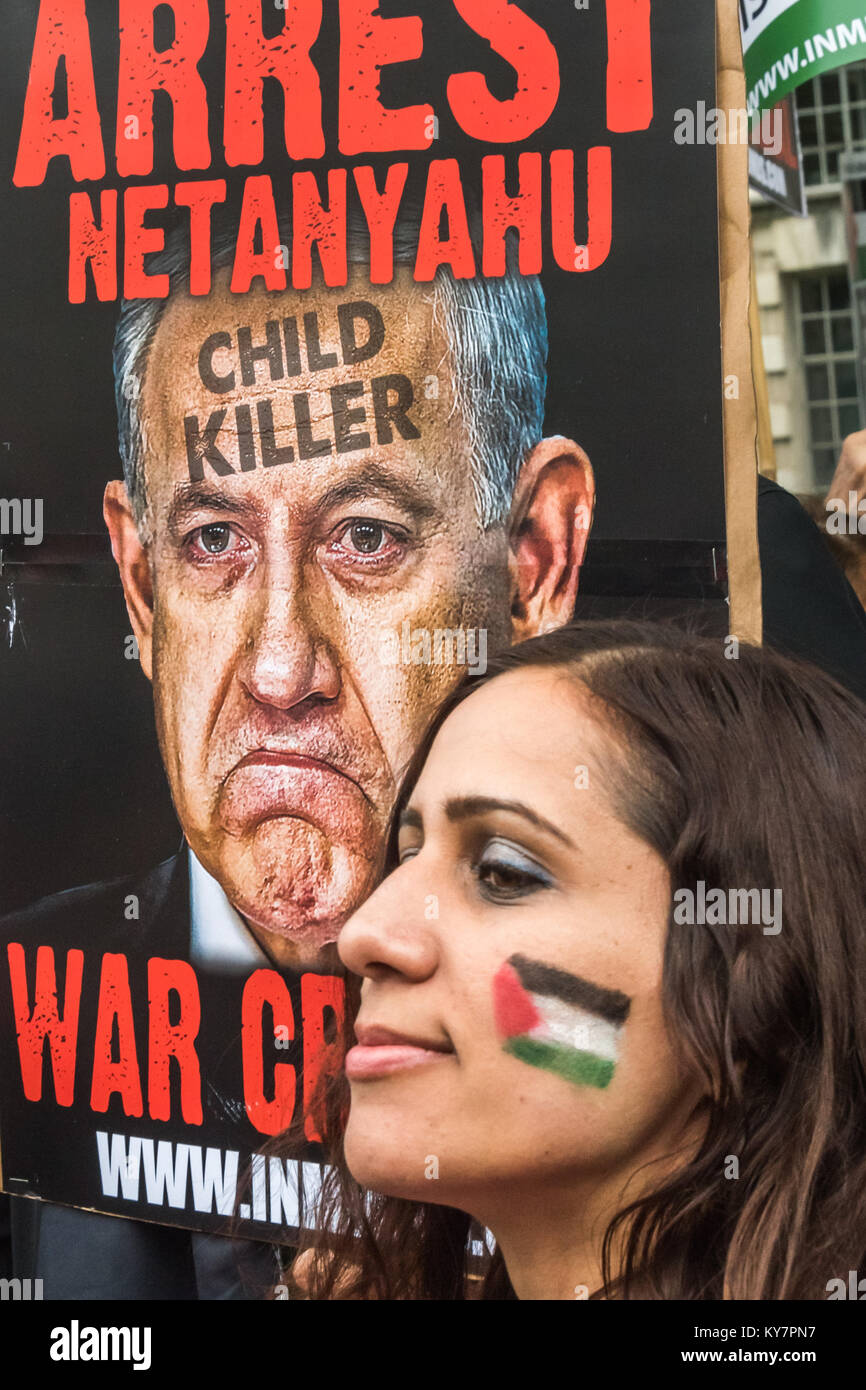 A woman with a Palestinian flag painted on her face in front of a ...