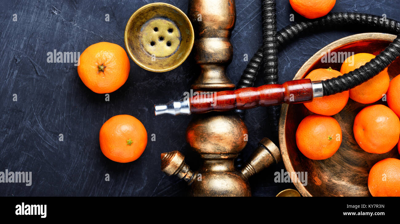 Smoking smoking shisha in east style with tobacco aroma of mandarin ...