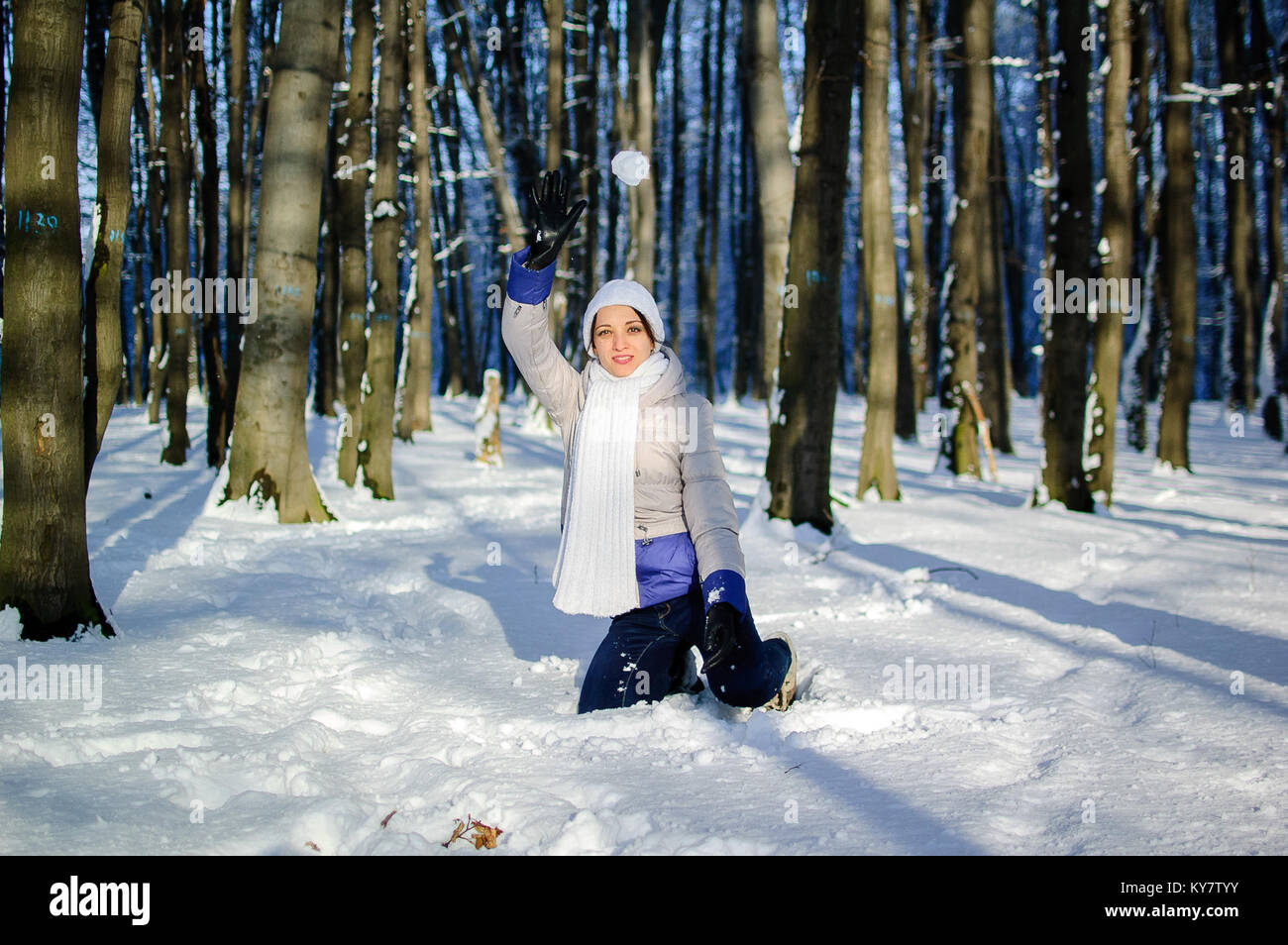 Young Woman Throwing a Snowball Playing in Snowy Park During a Sunny ...