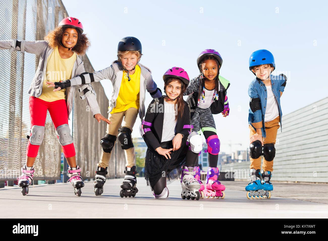 Portrait of happy kids, multiethnic boys and girls in safety gear ...