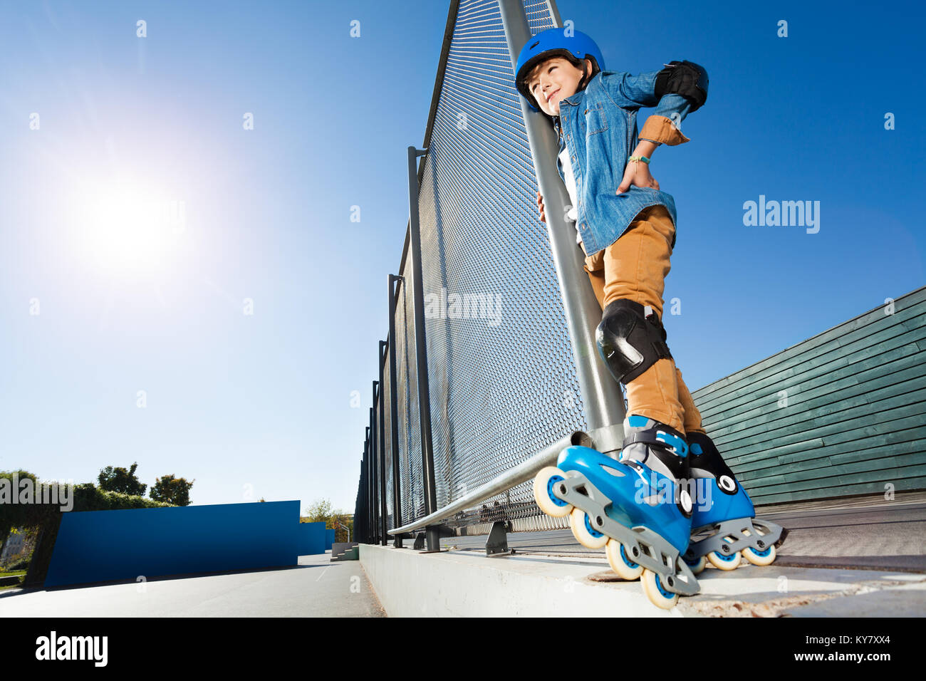 Bottom view portrait of preteen boy, inline skater in protective gear ...