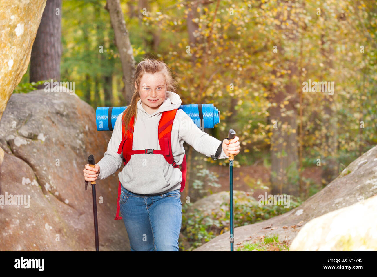 Portrait of teenage girl with backpack and trekking sticks walking ...