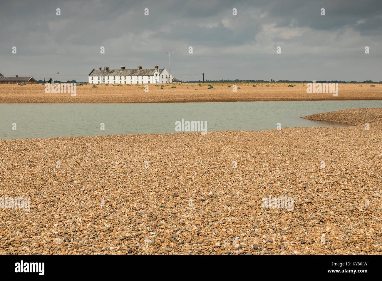 An image of coastguard cottages shot across the shingle beach at ...