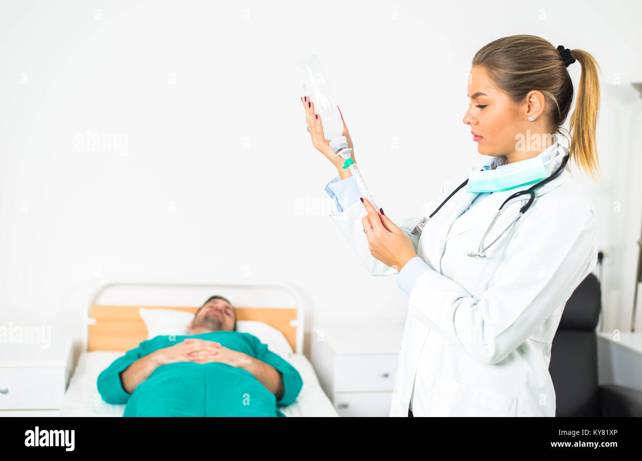 female doctor prepares an injection while the patient is in bed at ...