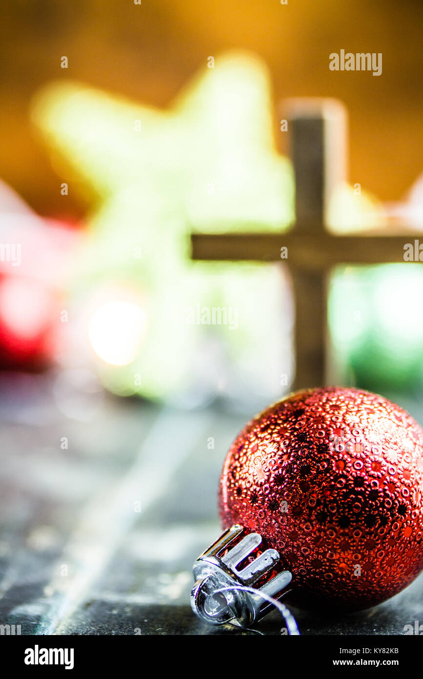 Traditional Christmas holiday ornaments and a holy Christian cross on a ...
