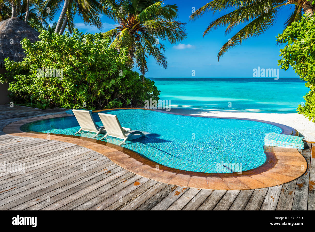 Private oceanfront pool with submerged loungers in a luxury resort in ...