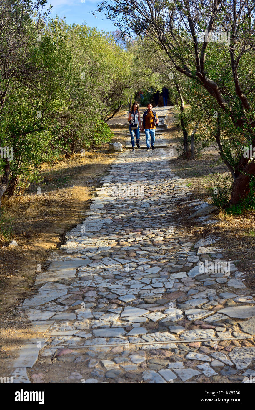 Marble stone footpath between trees with two people walking Stock Photo ...